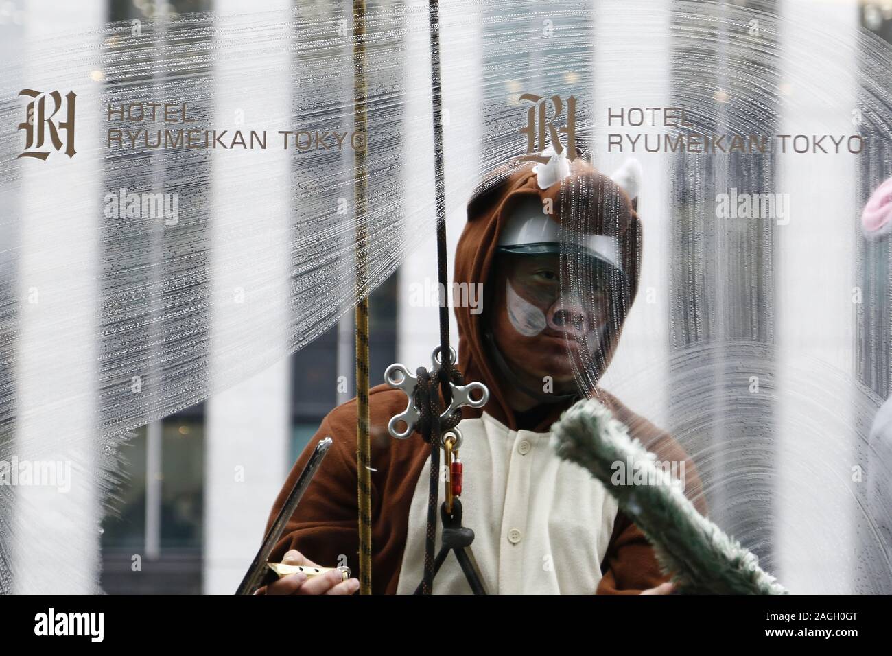 Tokyo, Japan. 19th Dec, 2019. A window cleaner dressed as a wild boar ...