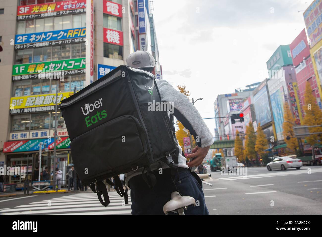 An Uber Eats cyclist rides through Chuo-dori Avenue cross road in ...