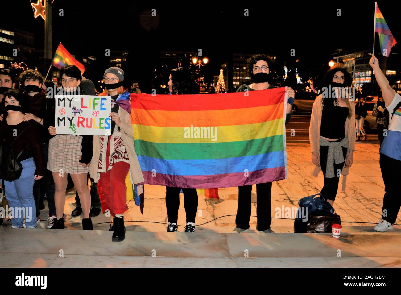 Protesters hold an LGBT rainbow flag and a placard during the ...