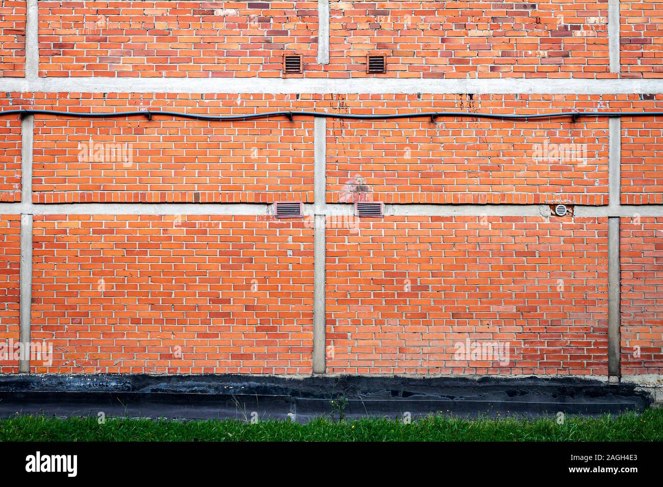 Red lined brick wall background with green grass Stock Photo - Alamy