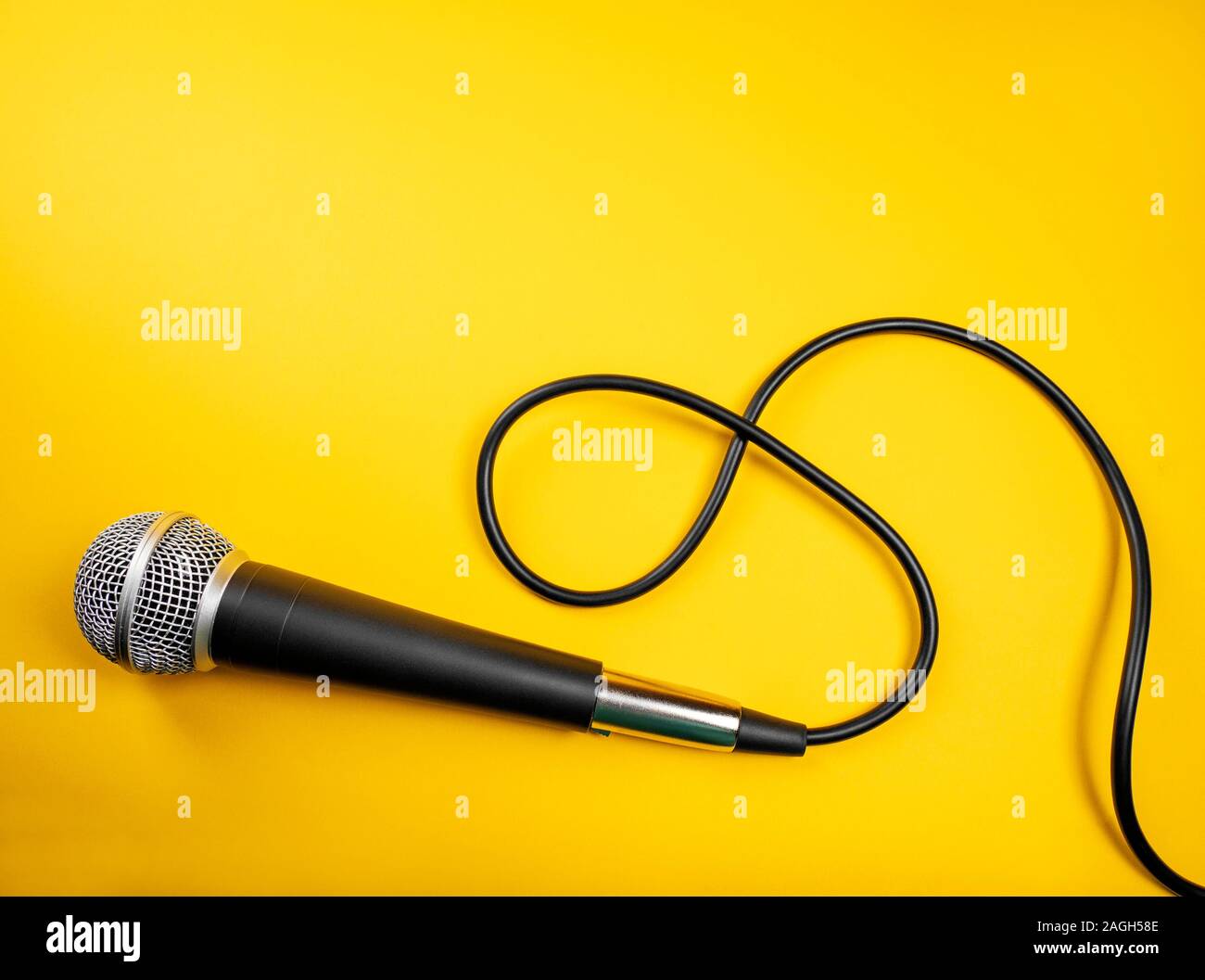 Microphone with curly cable on yellow background Stock Photo - Alamy