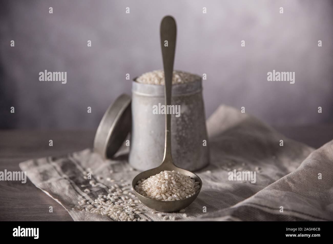 Raw Rice on ladle with a container and a towel Stock Photo - Alamy