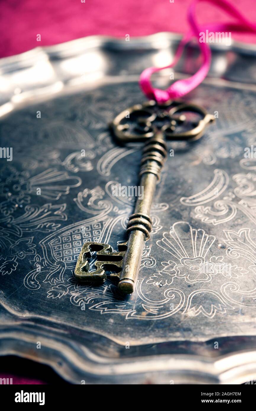 ornate key with ribbon on a silver plate Stock Photo - Alamy