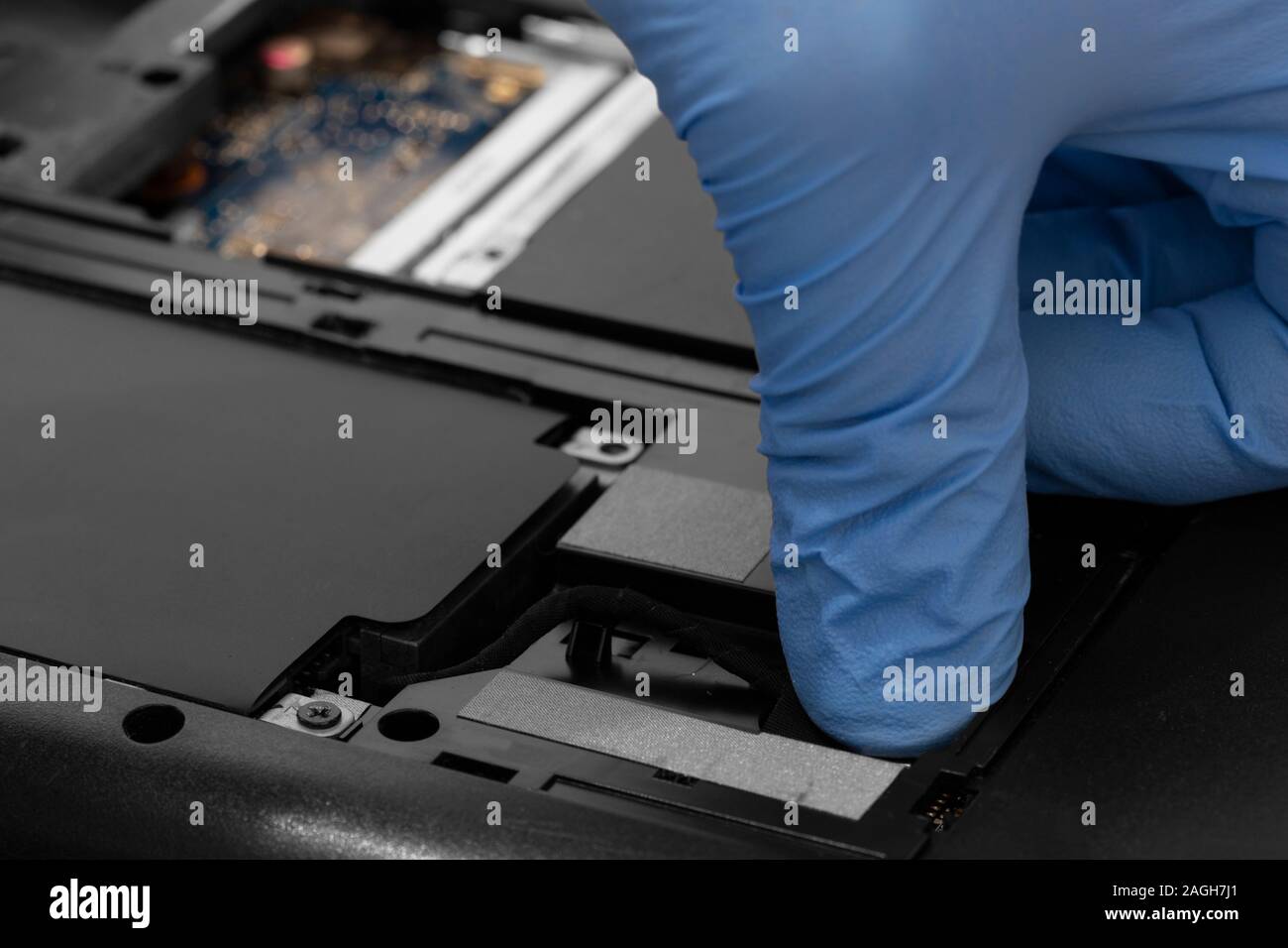 Technician connecting hard drive HDD cable to a laptop computer ...