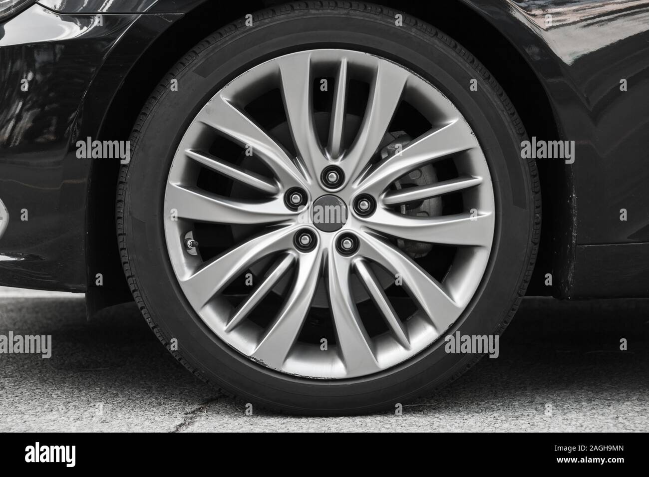 Modern luxury car wheel on a light alloy disc, close up photo Stock Photo - Alamy