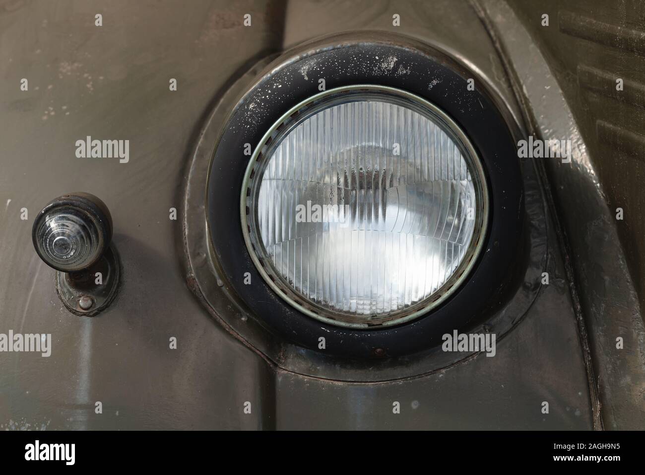 Round headlight and a turn light of a military car, old-timer vehicle ...