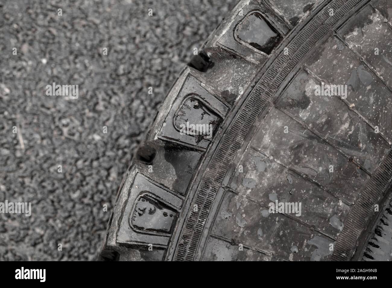 Damaged old used worn-out truck tire lays on an asphalt road, close-up ...