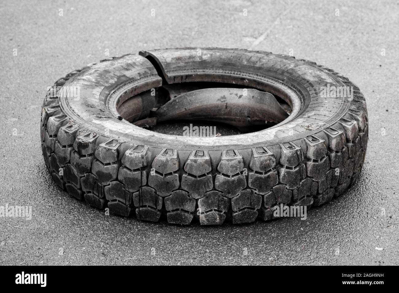 Damaged old used worn-out truck tire lays on an asphalt road Stock ...
