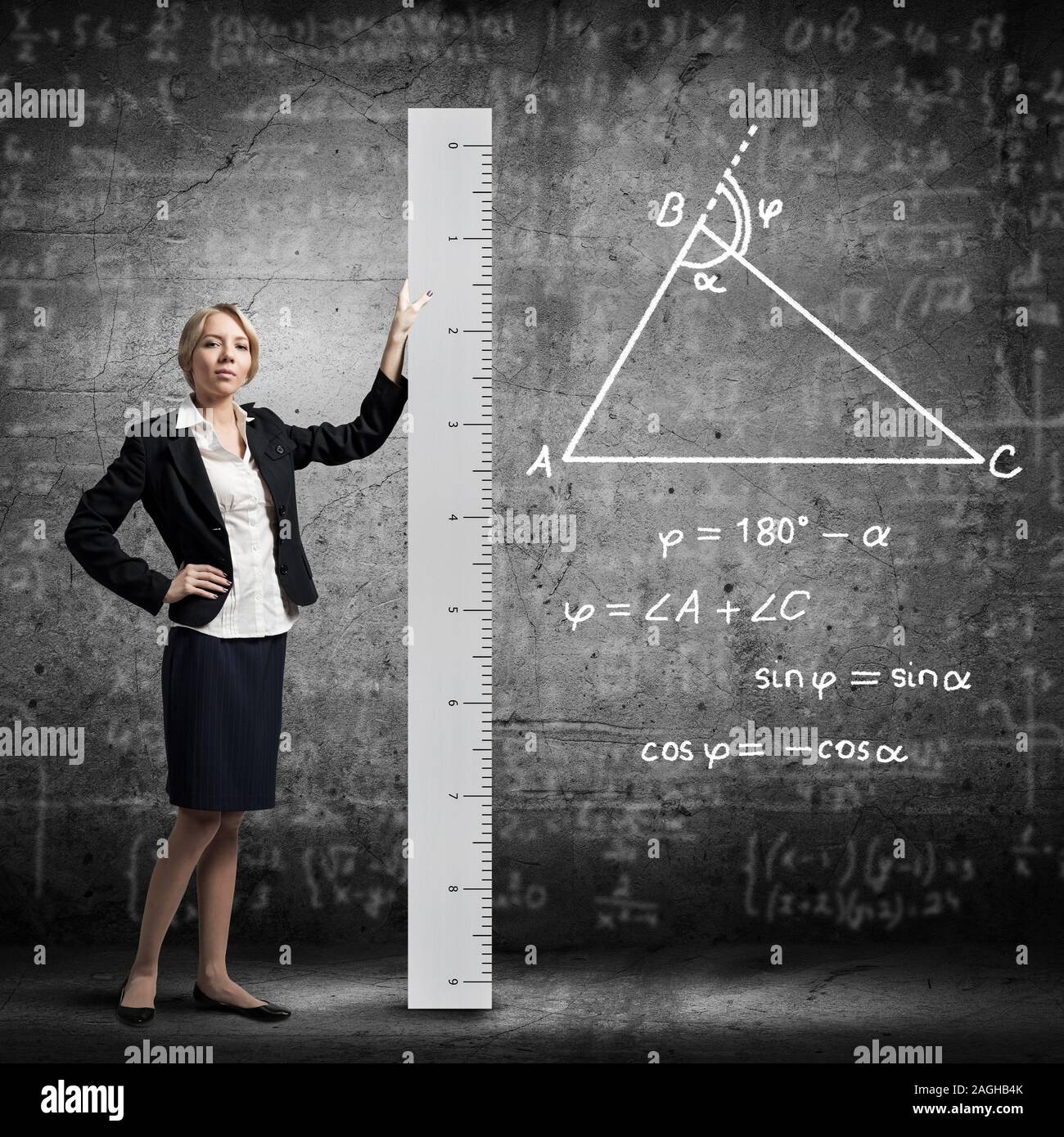 Young mathematics teacher holding big ruler Stock Photo - Alamy