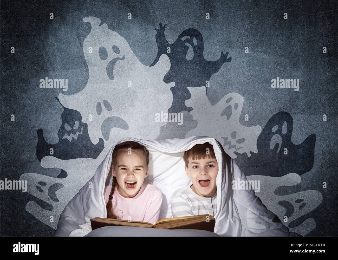 Happy little kids reading book in bed Stock Photo - Alamy