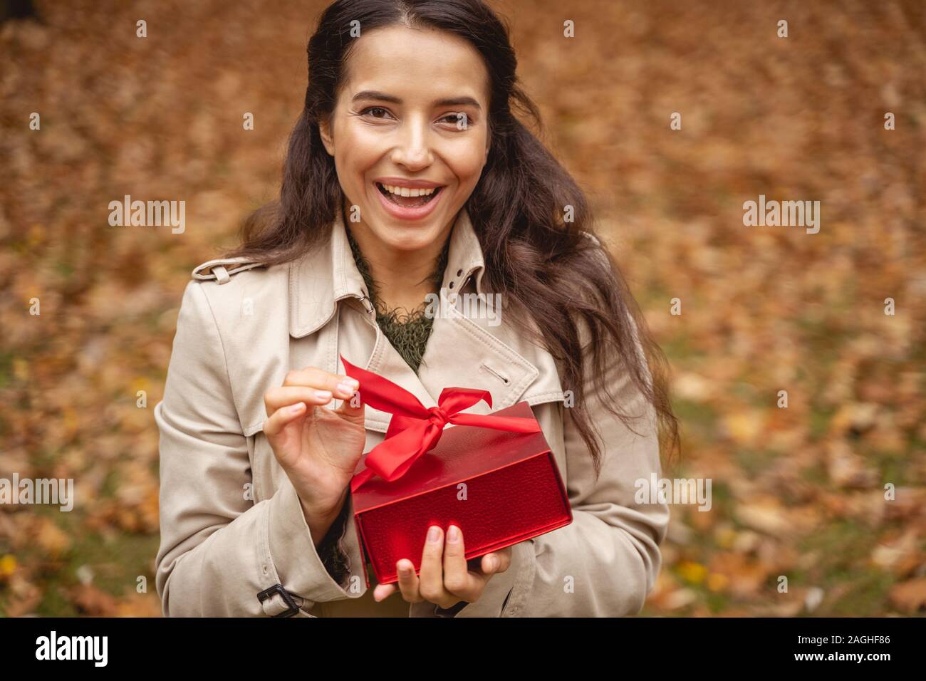 Joyful longhaired female person demonstrating her present Stock Photo ...