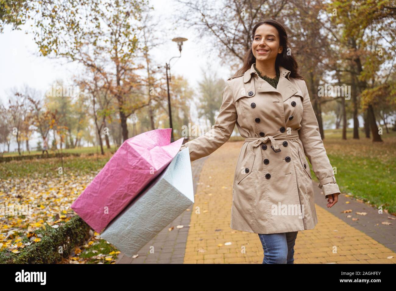 Attractive brunette girl going home with smile Stock Photo - Alamy