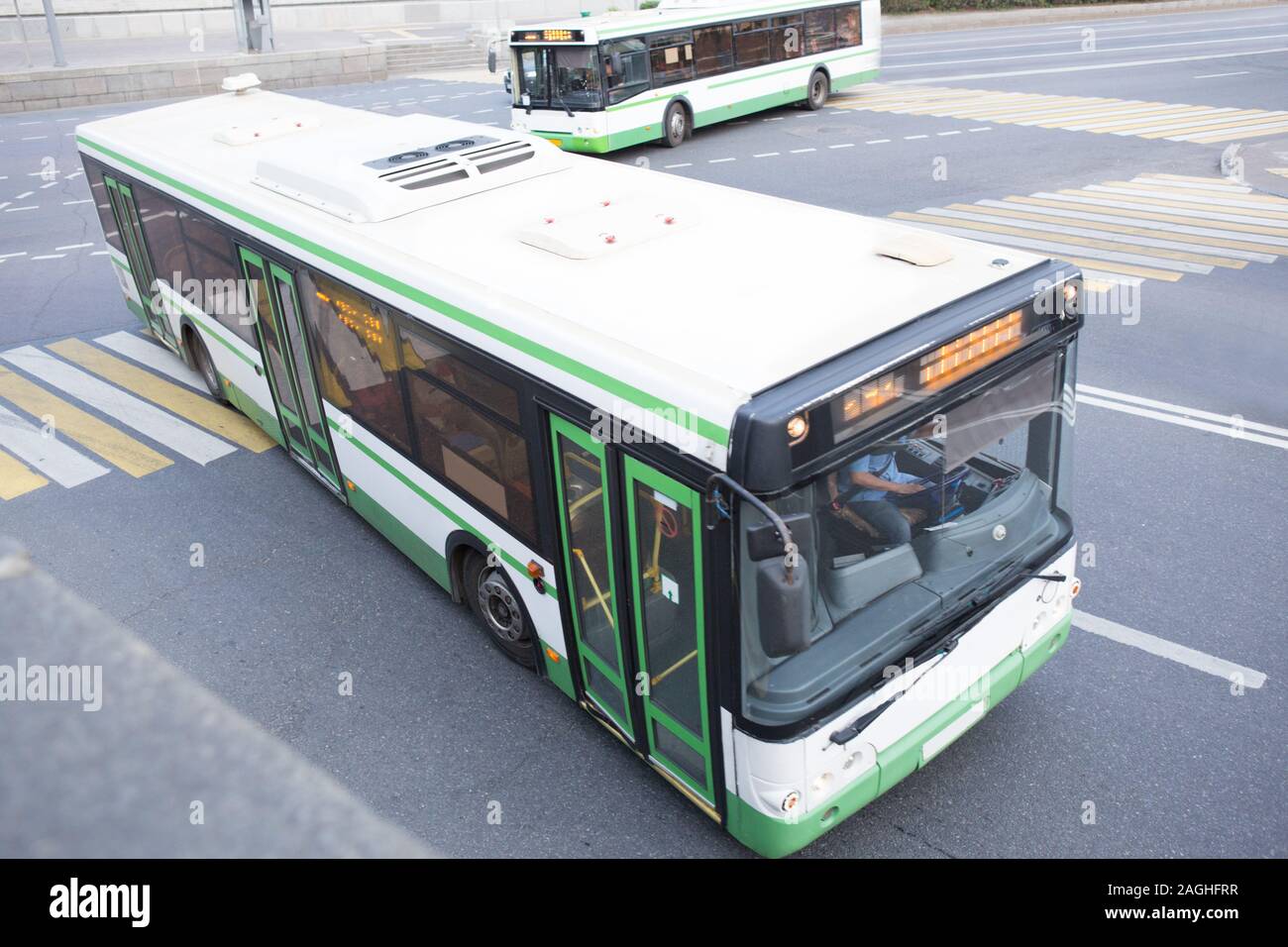 white city bus goes along street Stock Photo - Alamy