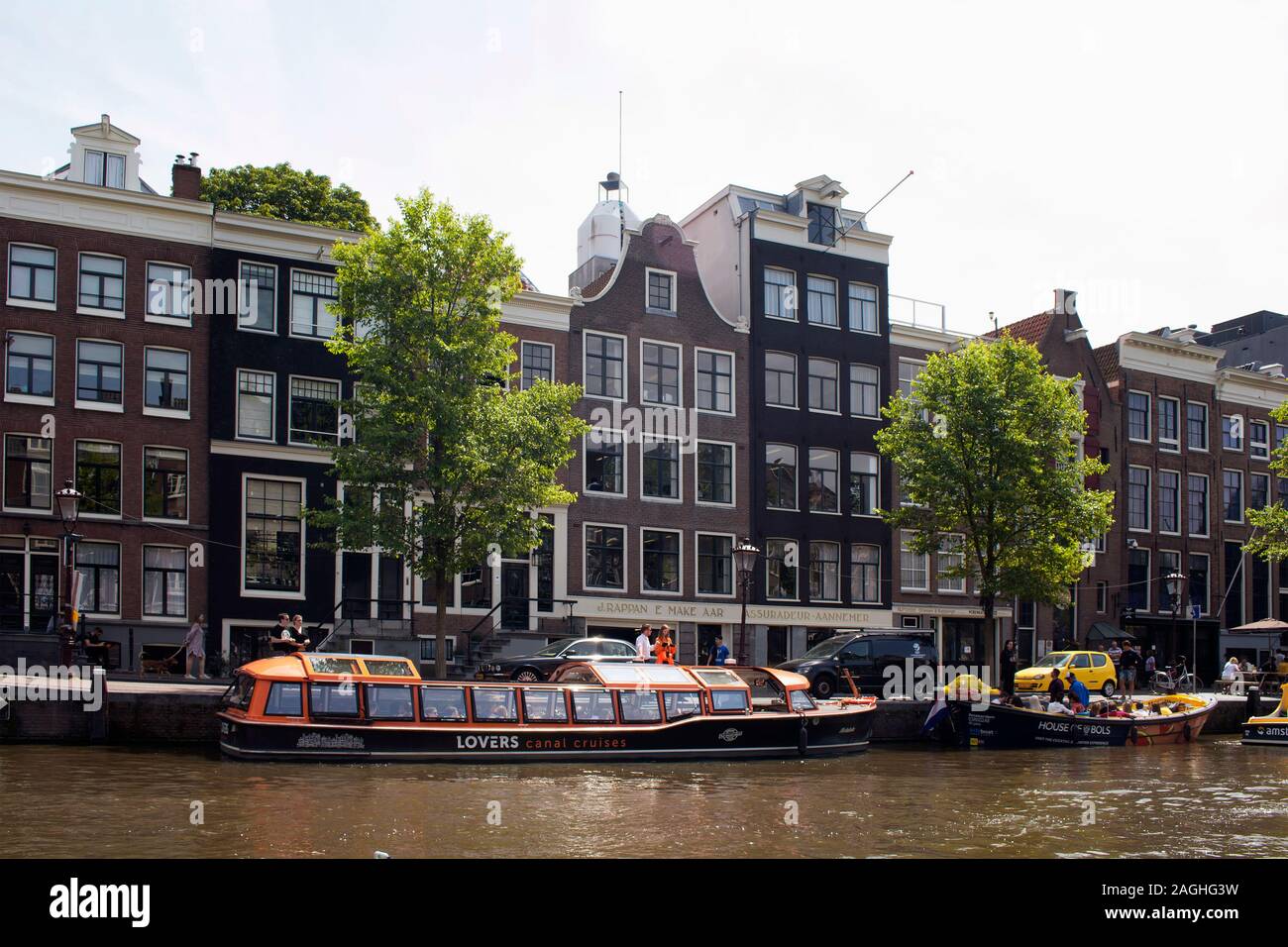 View of parked canal cruise tour boats, trees and historical ...