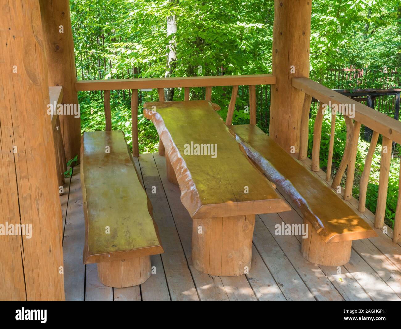 A table and two benches made of large solid wood in a log cabin Stock ...