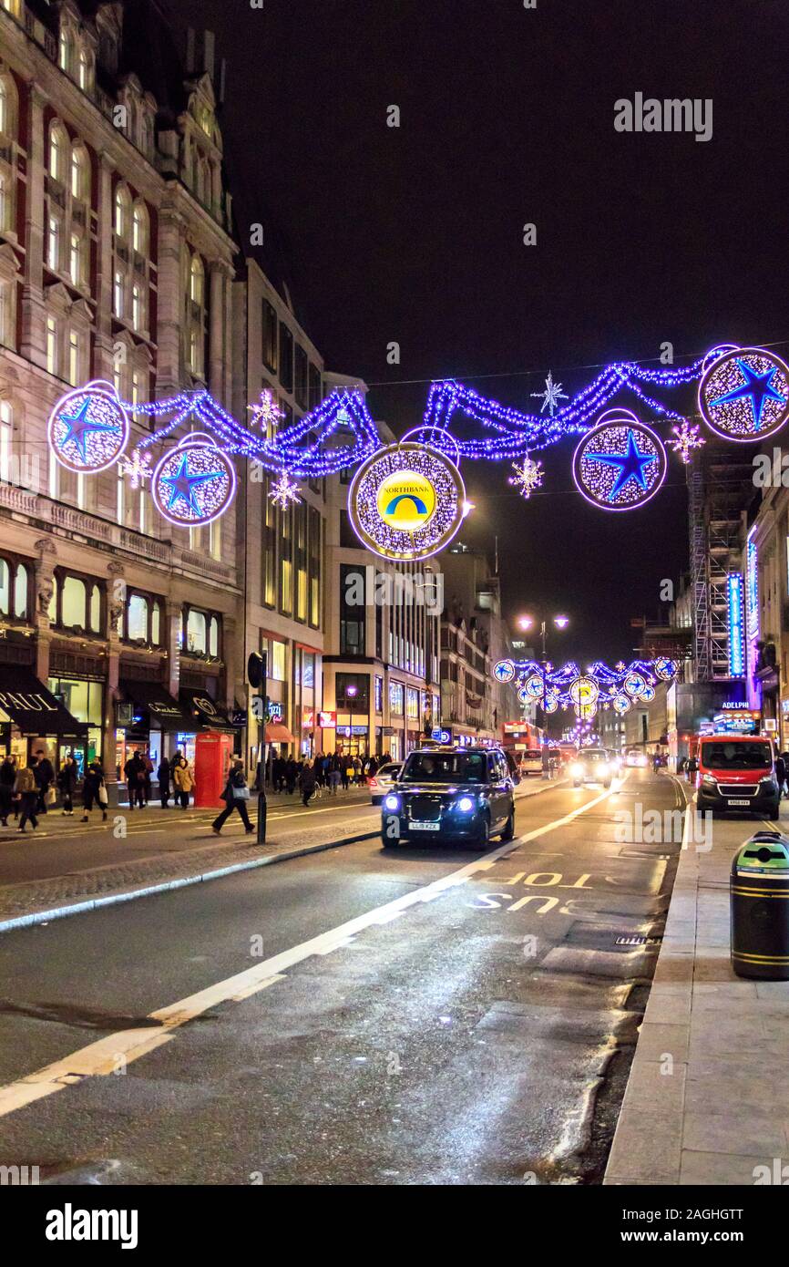 Shoppers and commuters in The Strand, illuminated by decorative ...