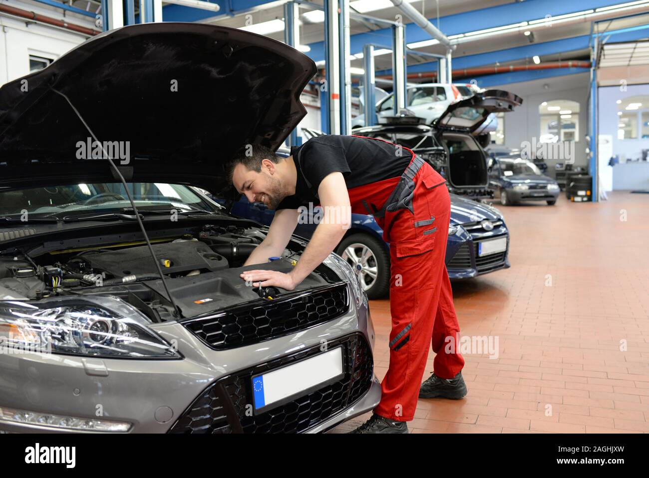 job and workplace - mechanic in a workshop repairing a car Stock Photo ...