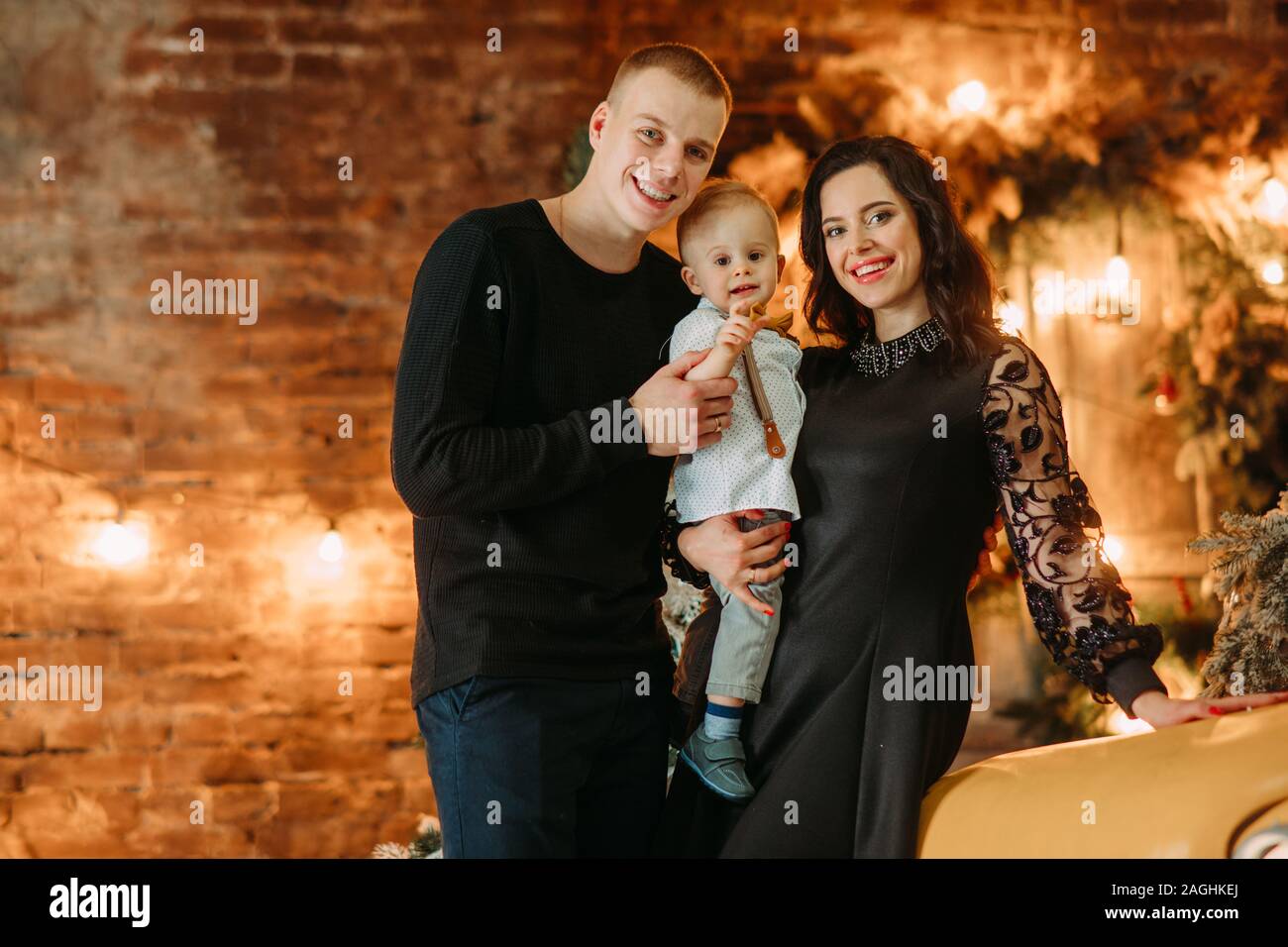 Happy family poses against background of Christmas tree and decorations ...