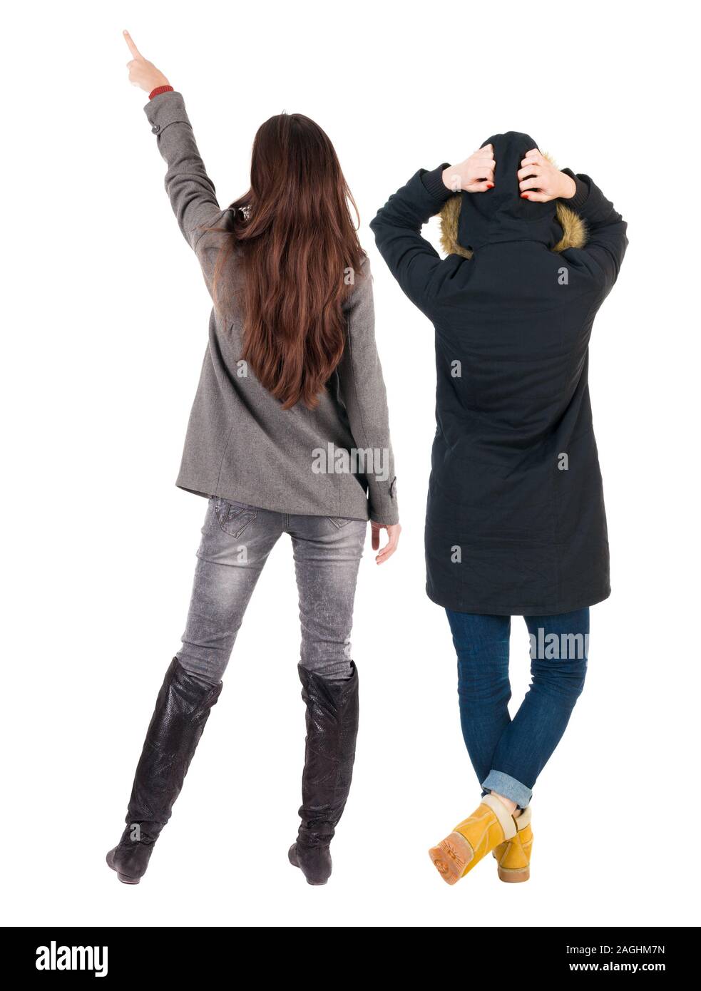 Back view of two pointing young girl in winter jacket. Rear view people ...