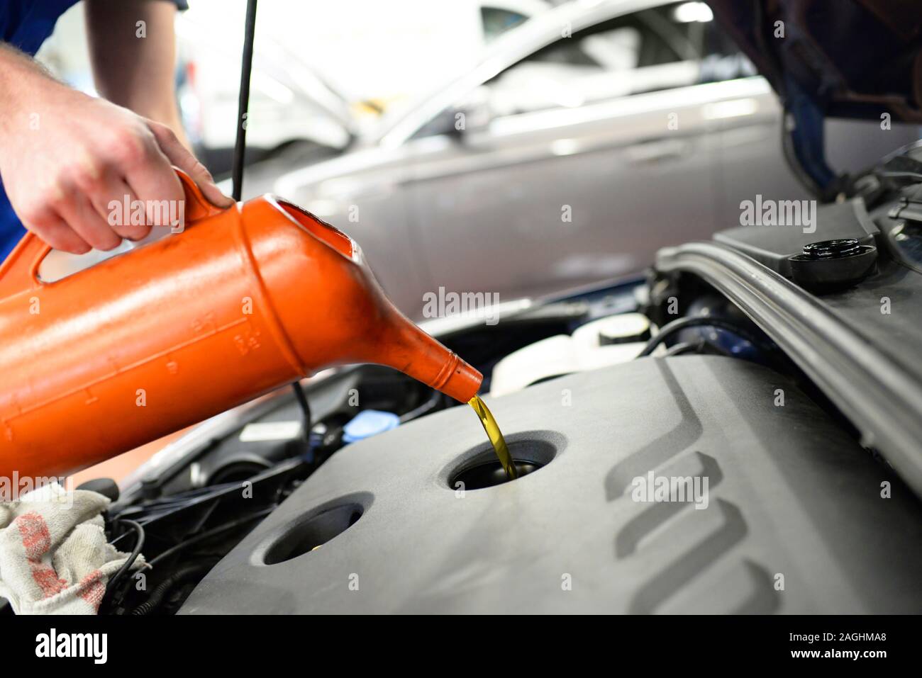 work in a garage - worker controls and changes the motoroil Stock Photo ...