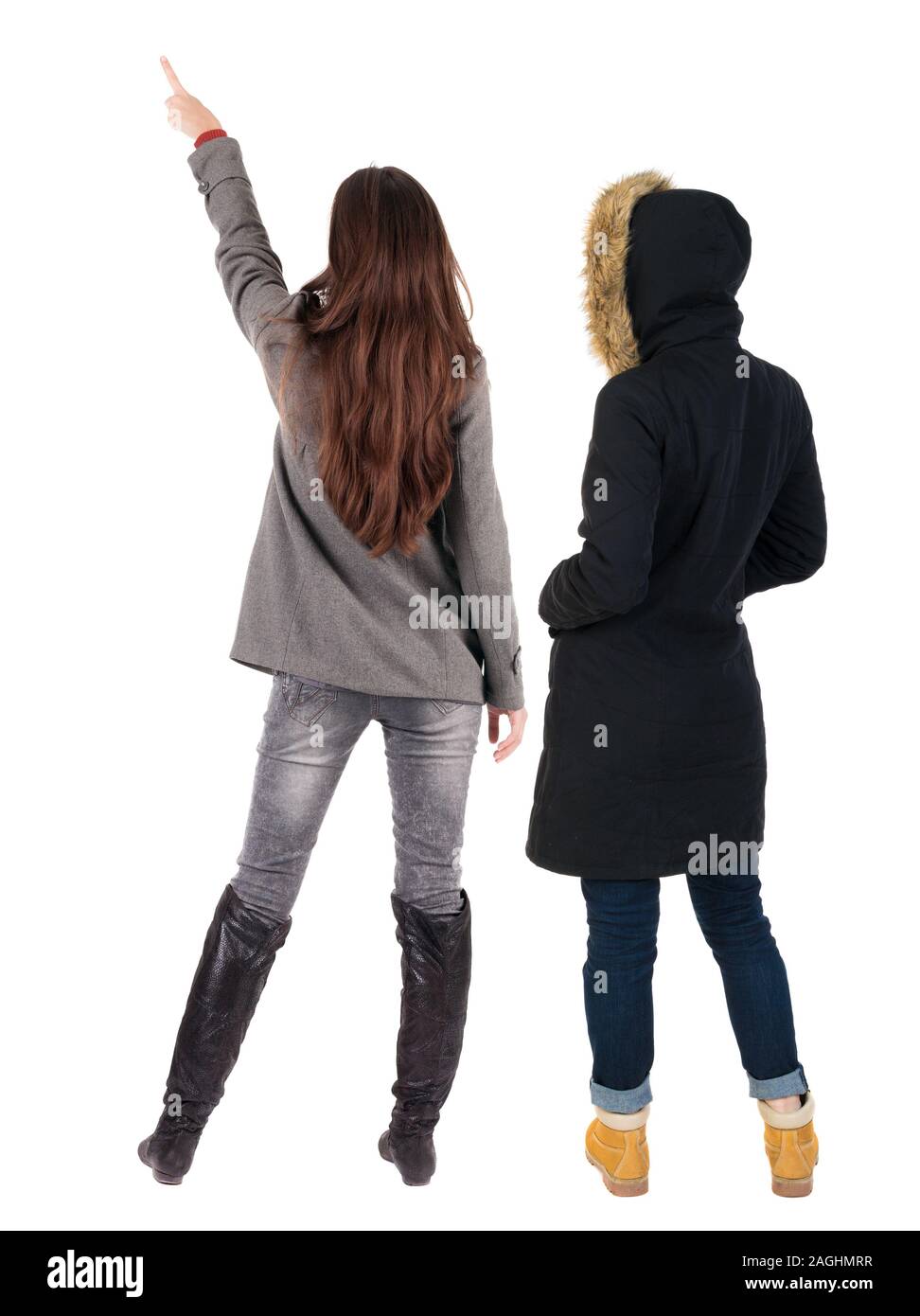 Back view of two pointing young girl in winter jacket. Rear view people ...