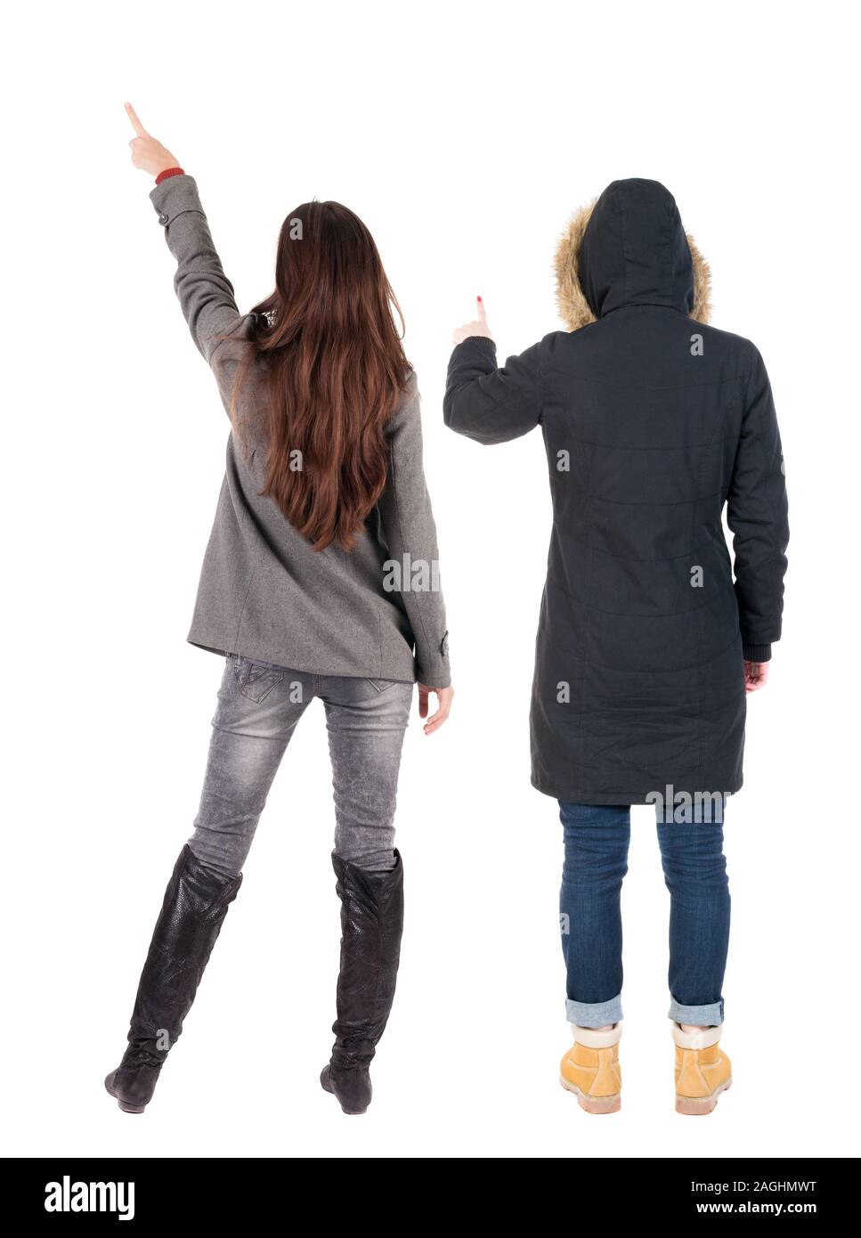 Back view of two pointing young girl in winter jacket. Rear view people ...