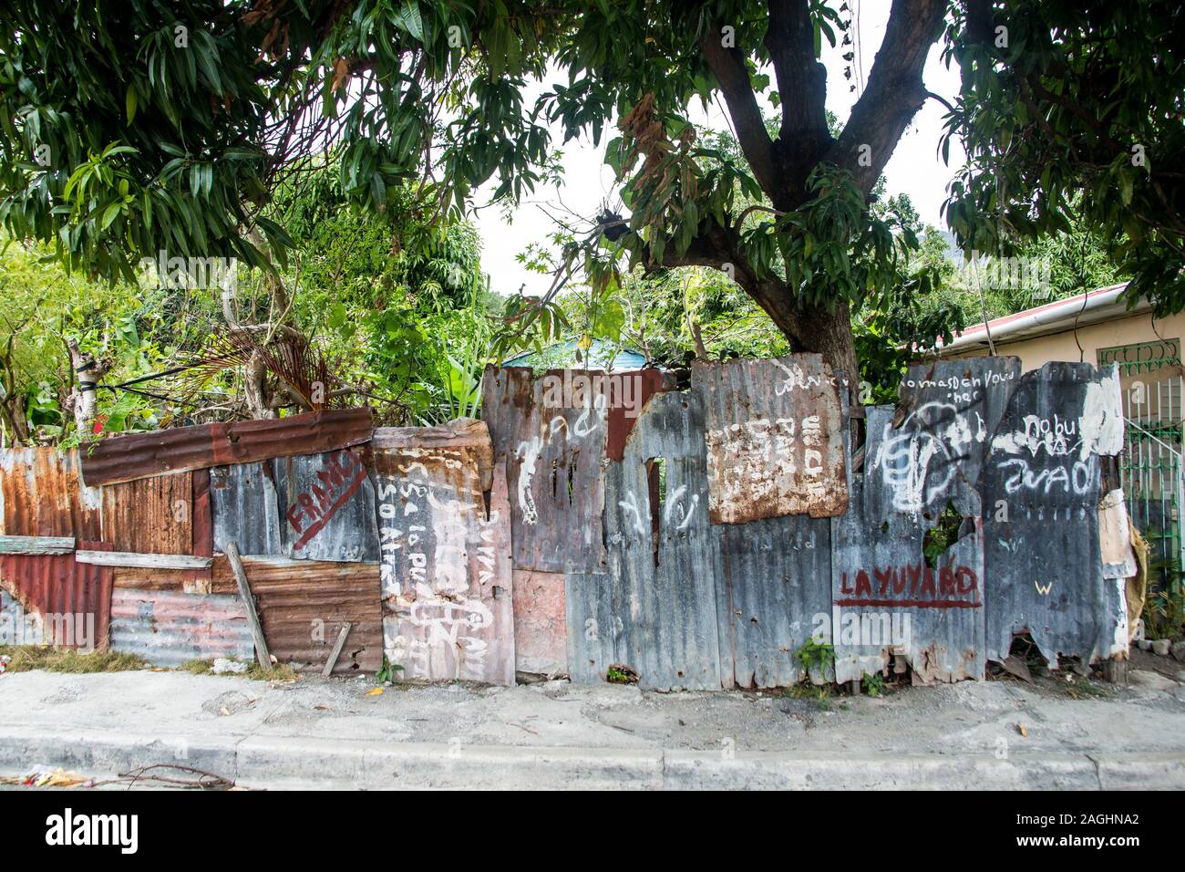 dramatic image of a fence made of metal and wood with graffiti painted ...