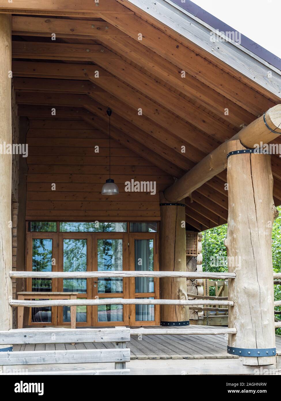 Cottage from log house of large trees a veranda Stock Photo - Alamy
