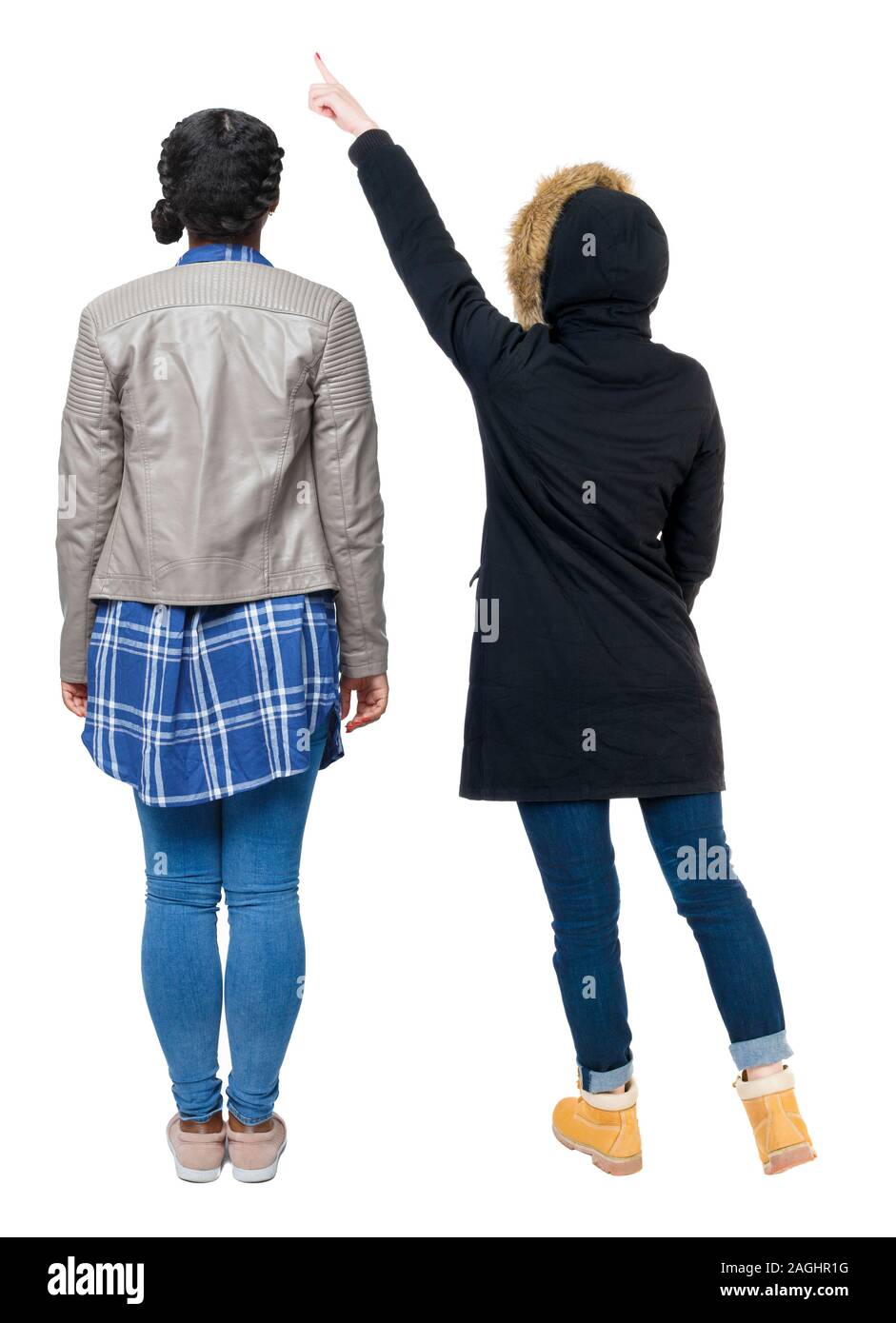 Back view of two pointing young girl in winter jacket. Rear view people ...