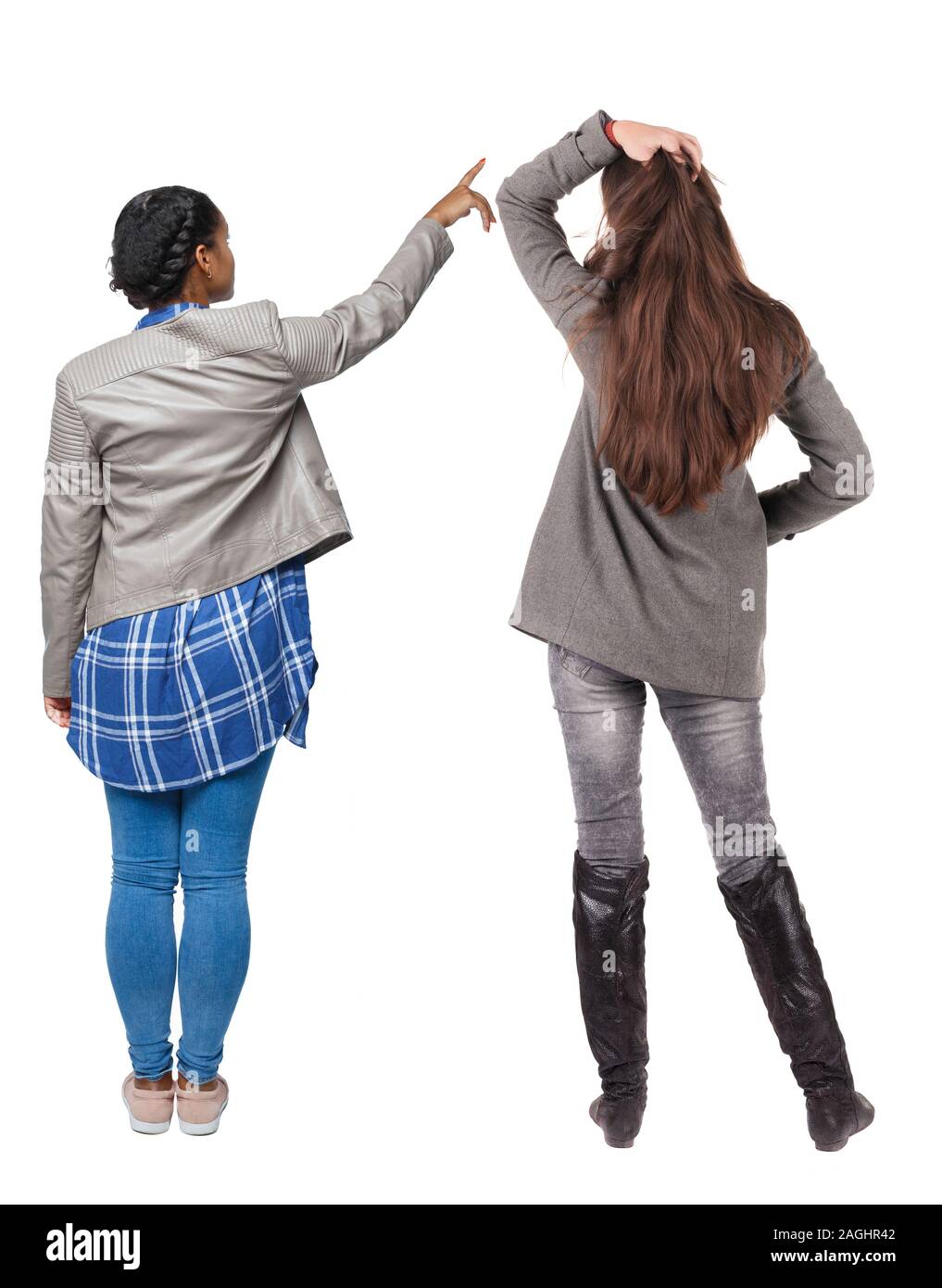 Back view of two pointing young girl in winter jacket. Rear view people ...