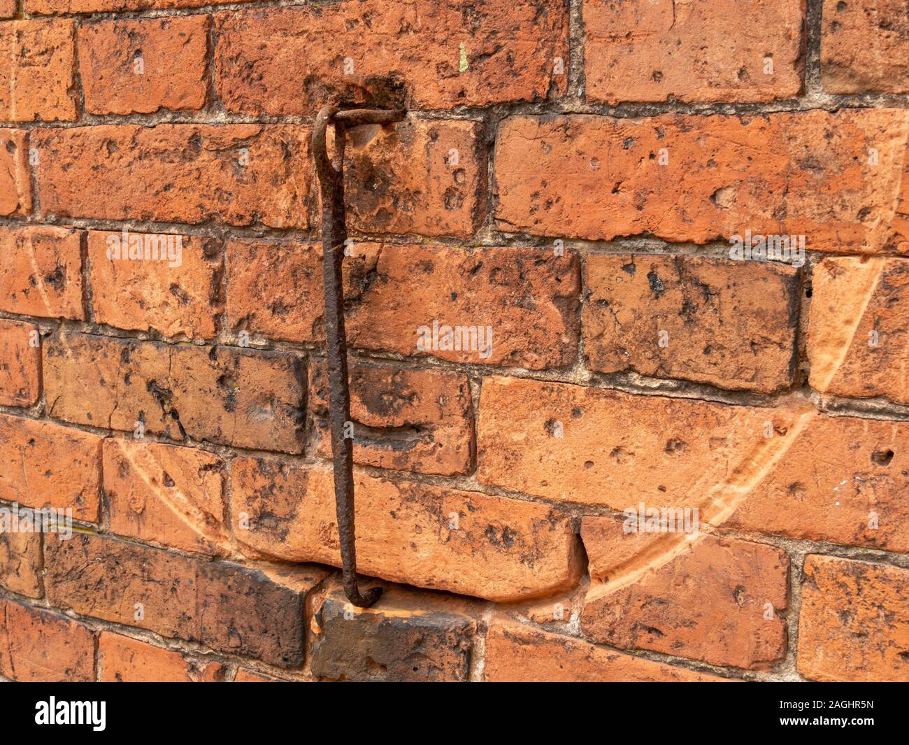 Old swinging rusty iron gate hook / stay which has worn a circular arc ...