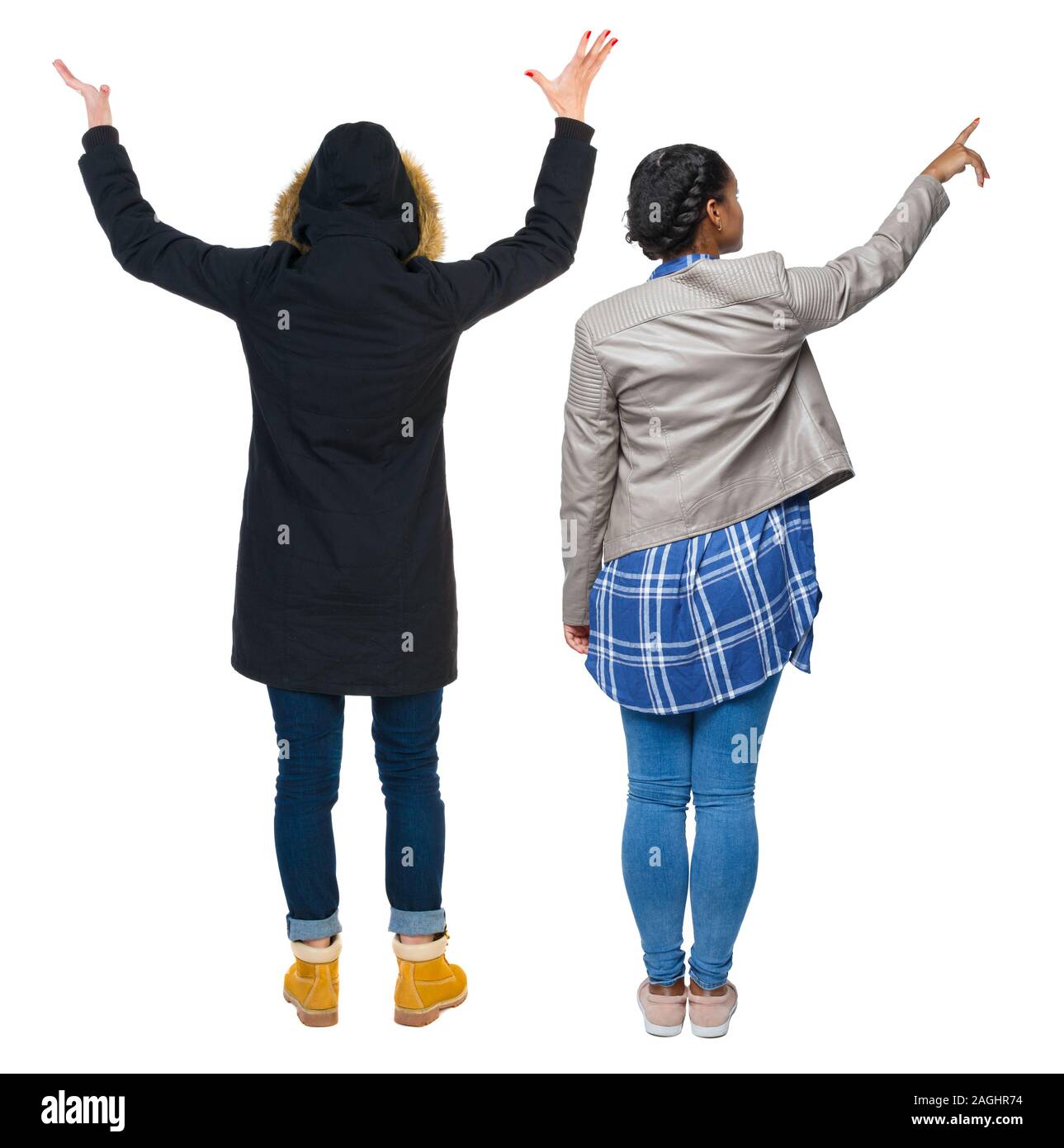 Back view of two pointing young girl in winter jacket. Rear view people ...