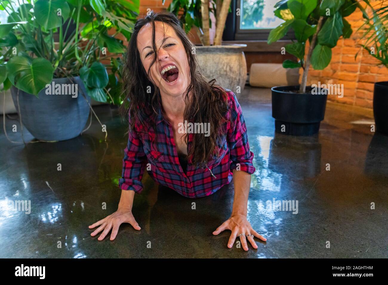 Crazy woman screams and pulls silly face during a grueling yoga workout ...