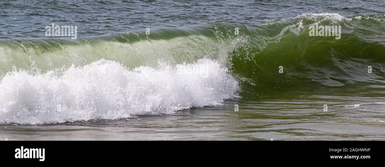 Horizontal picture of an Atlantic Ocean wave breaking along the shore ...