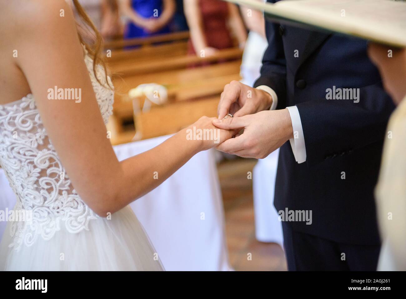 the bride and groom during the wedding ceremony put wedding rings on ...