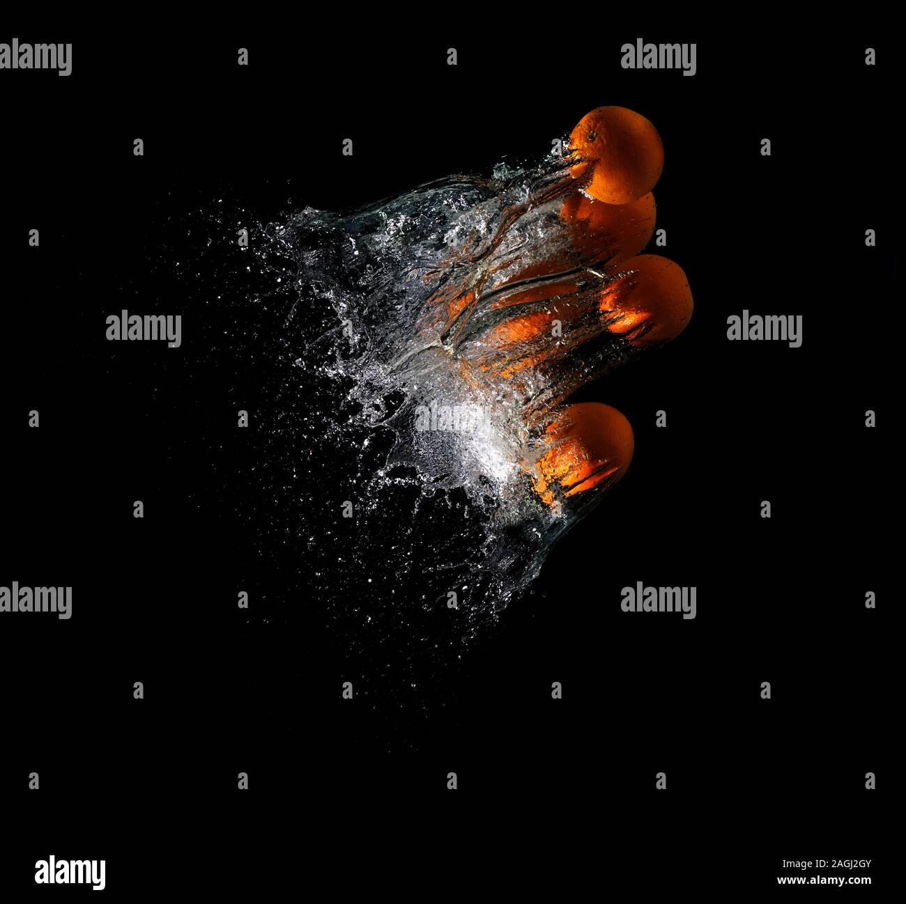 Five fresh oranges falling in water on a dark background Stock Photo ...