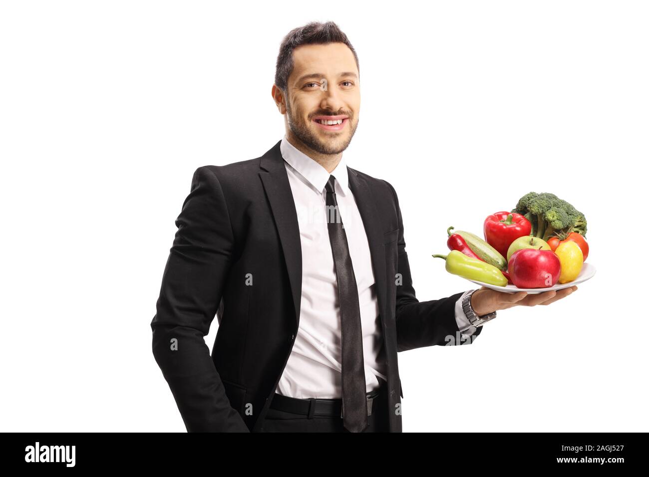 Businessman with a plate of fruits and vegetables smiling at the camera ...
