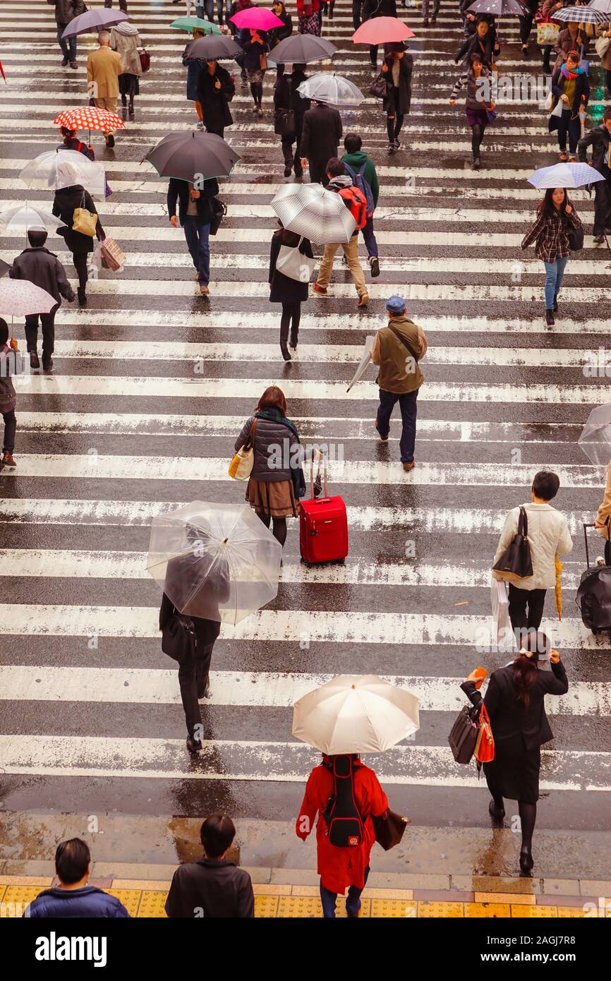 TOKYO, JAPAN - NOVEMBER 25, 2014: People walking under rain in a ...