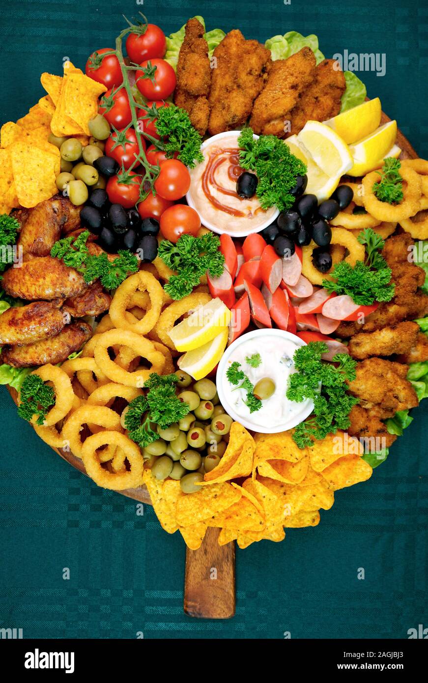 Party food charcuterie meat and snack grazing platter on wooden board ...