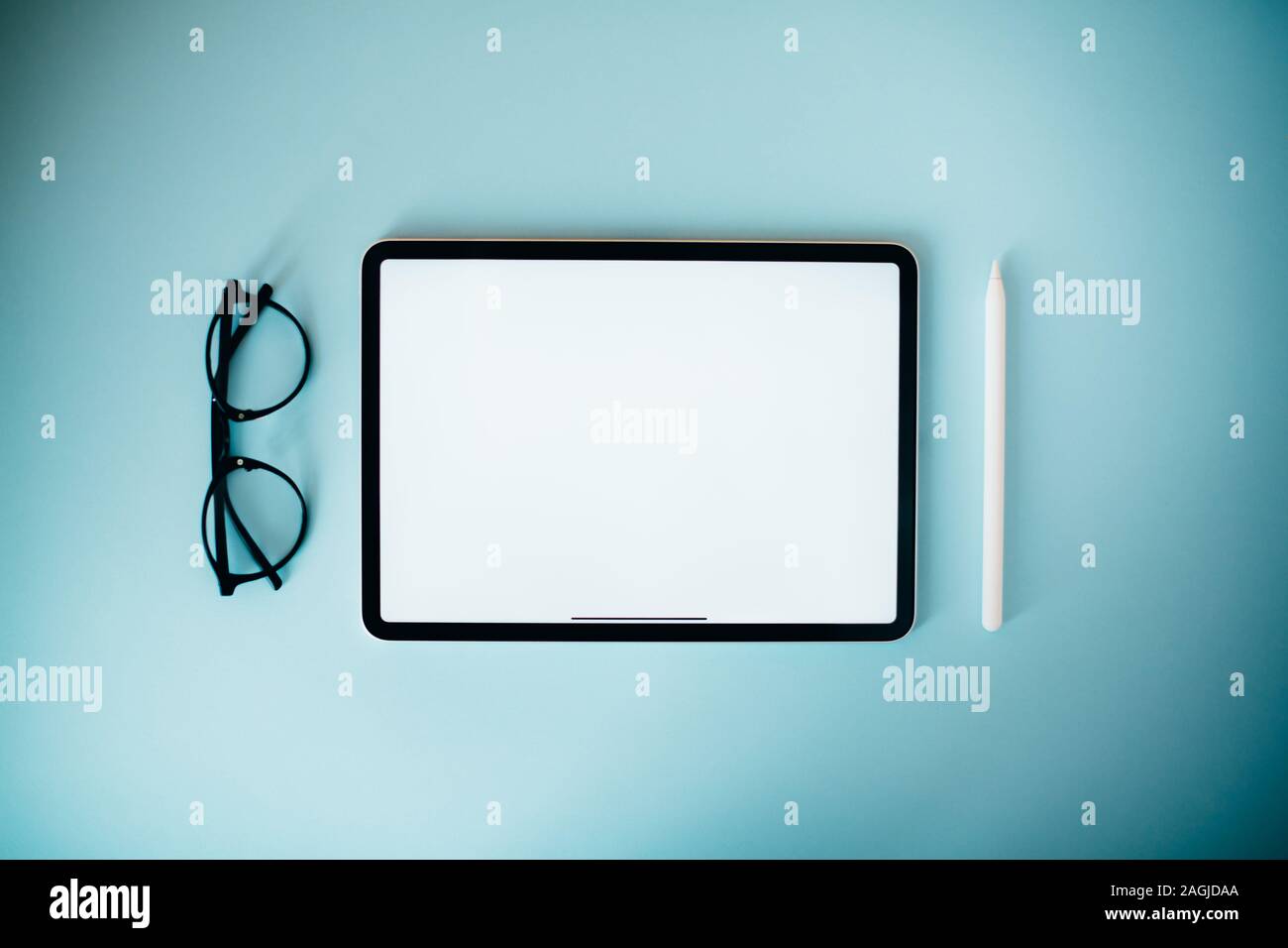 Digital tablet on blue background. Flat lay style. Clean white screen ...