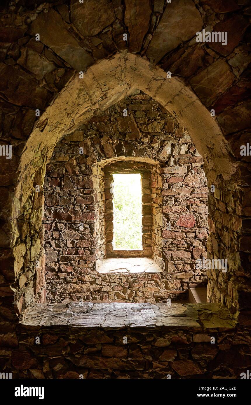 Medieval stone arch with tiny window illuminating the inside tower of ...