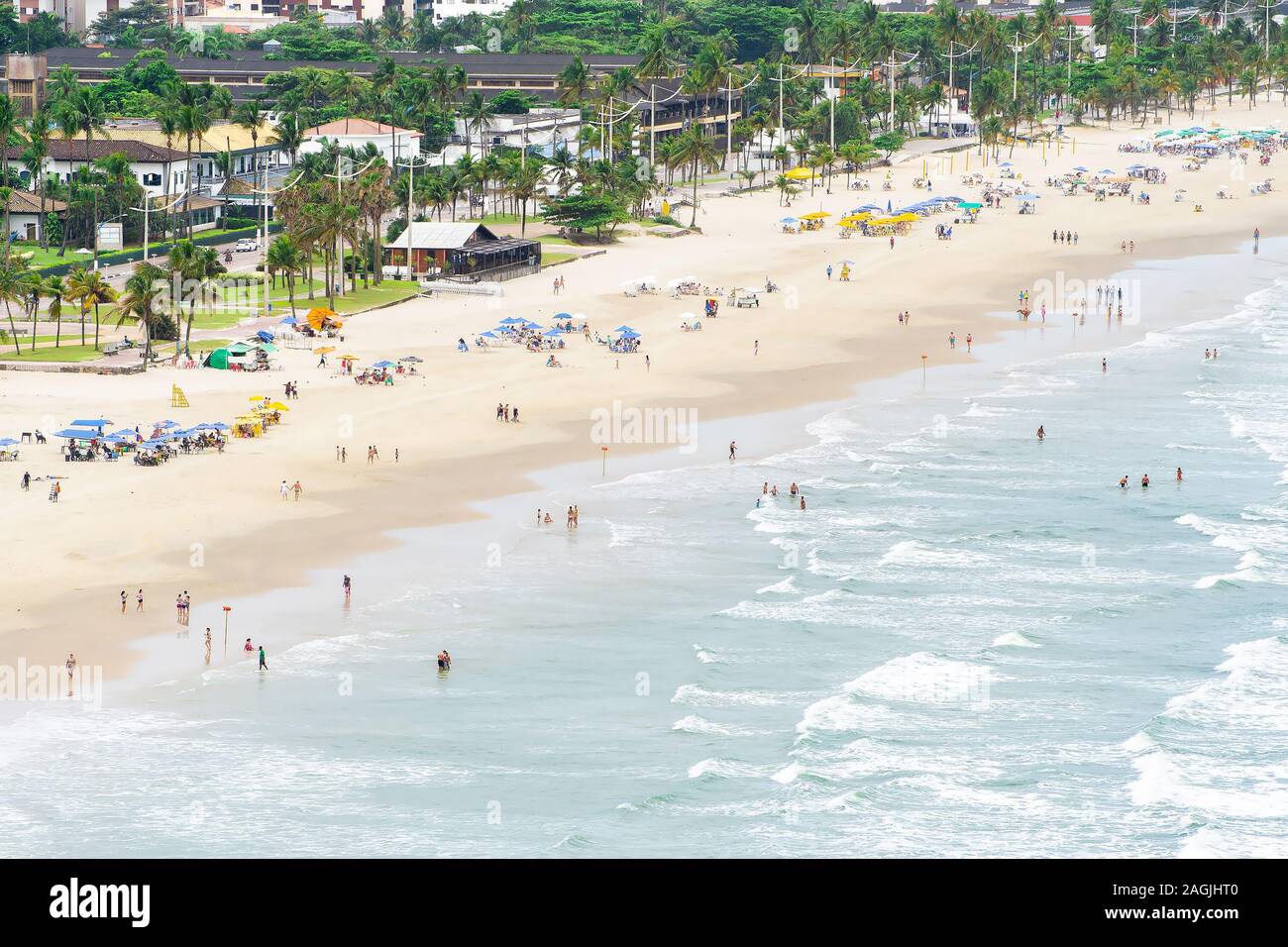 Aerial view of a seafront city, people on the beach on a beautiful day ...