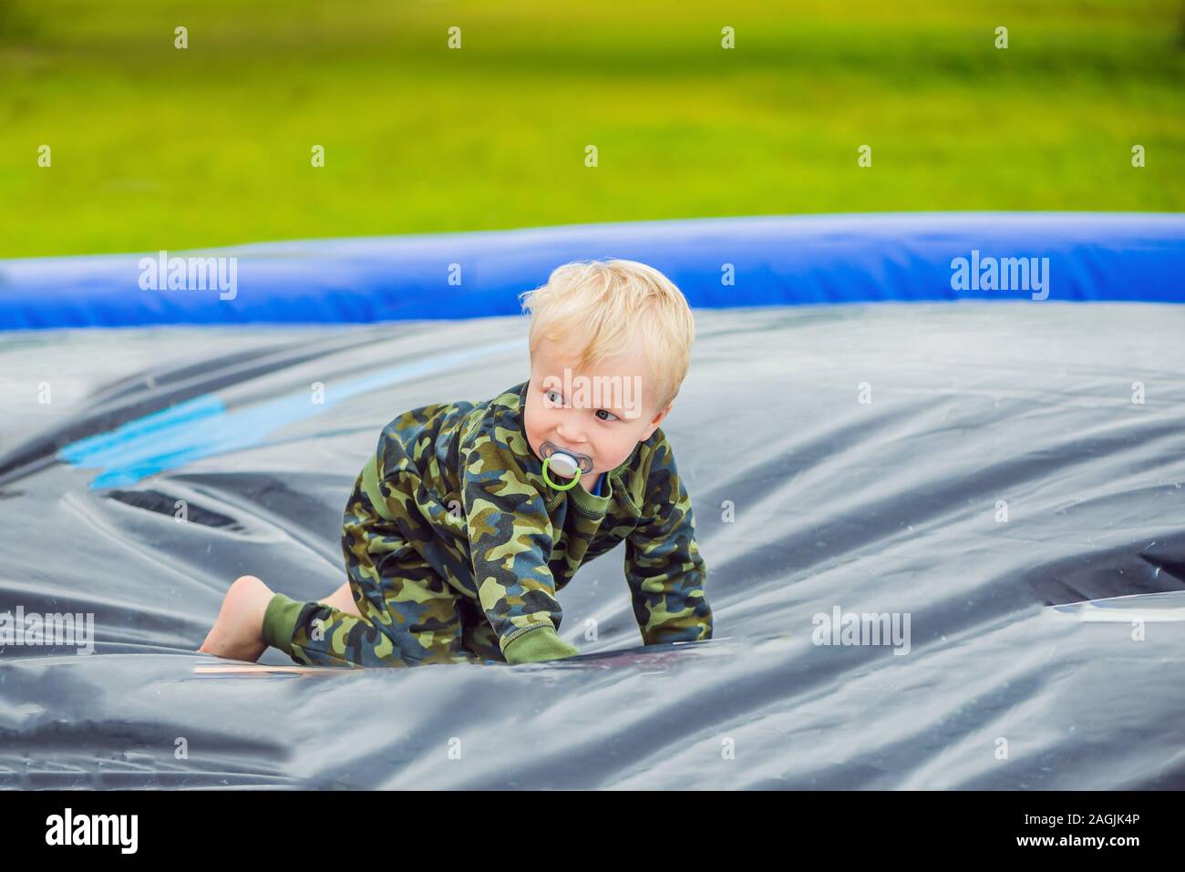 Little boy enjoying jumping on trampoline summer day outside Stock ...