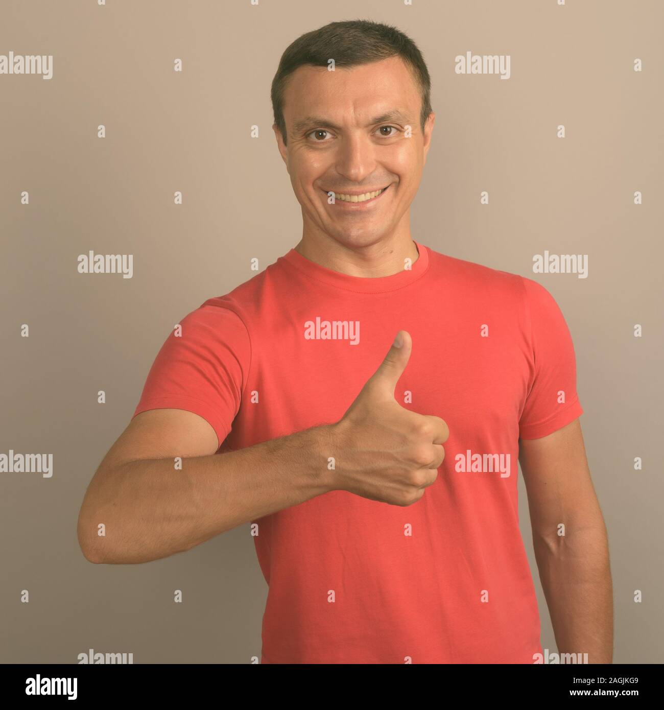 Man wearing red shirt against gray background Stock Photo - Alamy