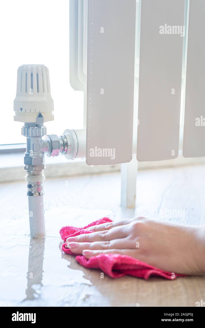 Female hand with rag cleaning water from heating radiator Stock Photo ...