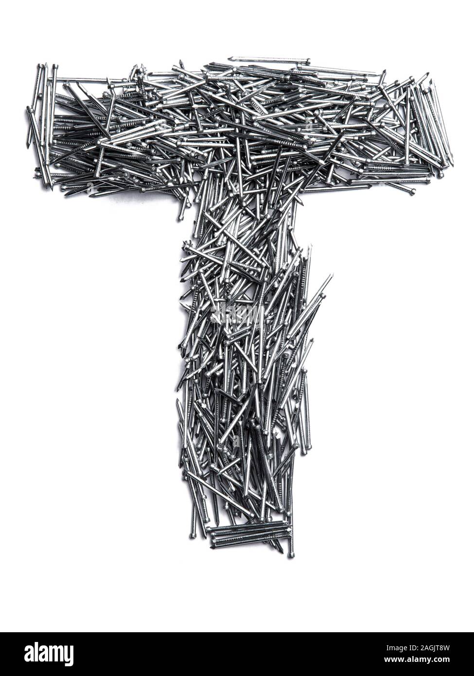 Letter T of the English alphabet from small iron nails on a white ...