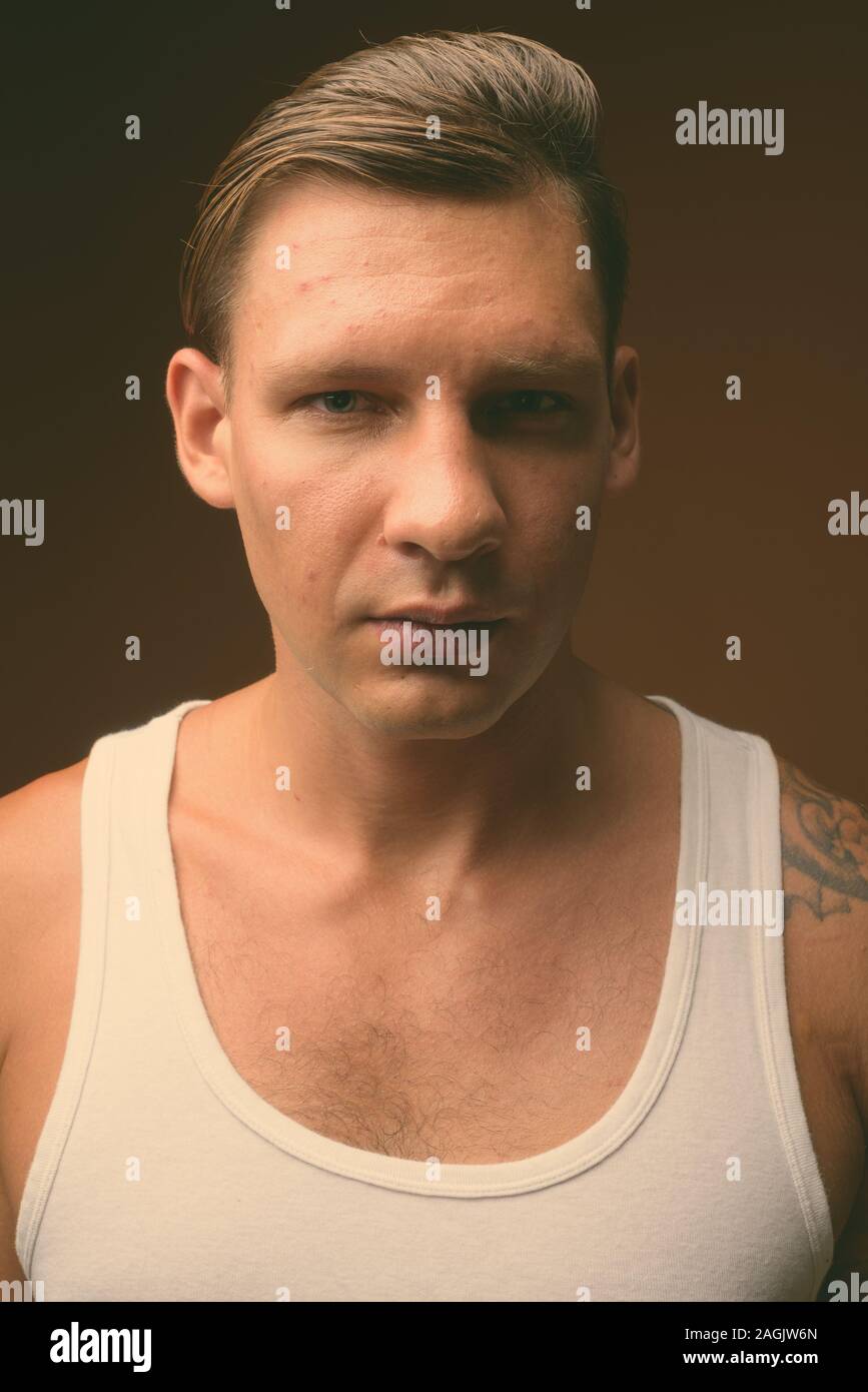 Muscular man wearing white tank top against black background in black ...