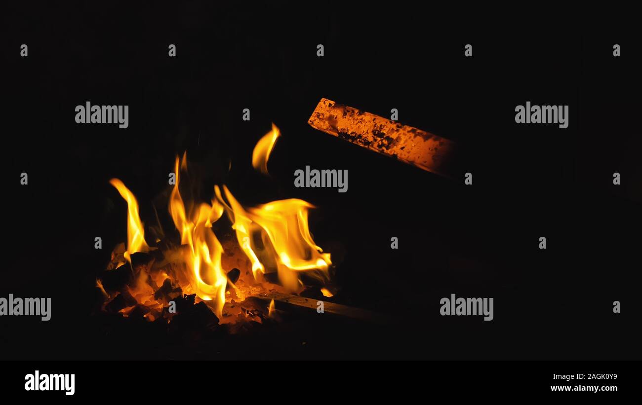 Forge fire in furnace. Blacksmith tempers a steel product in a stove ...