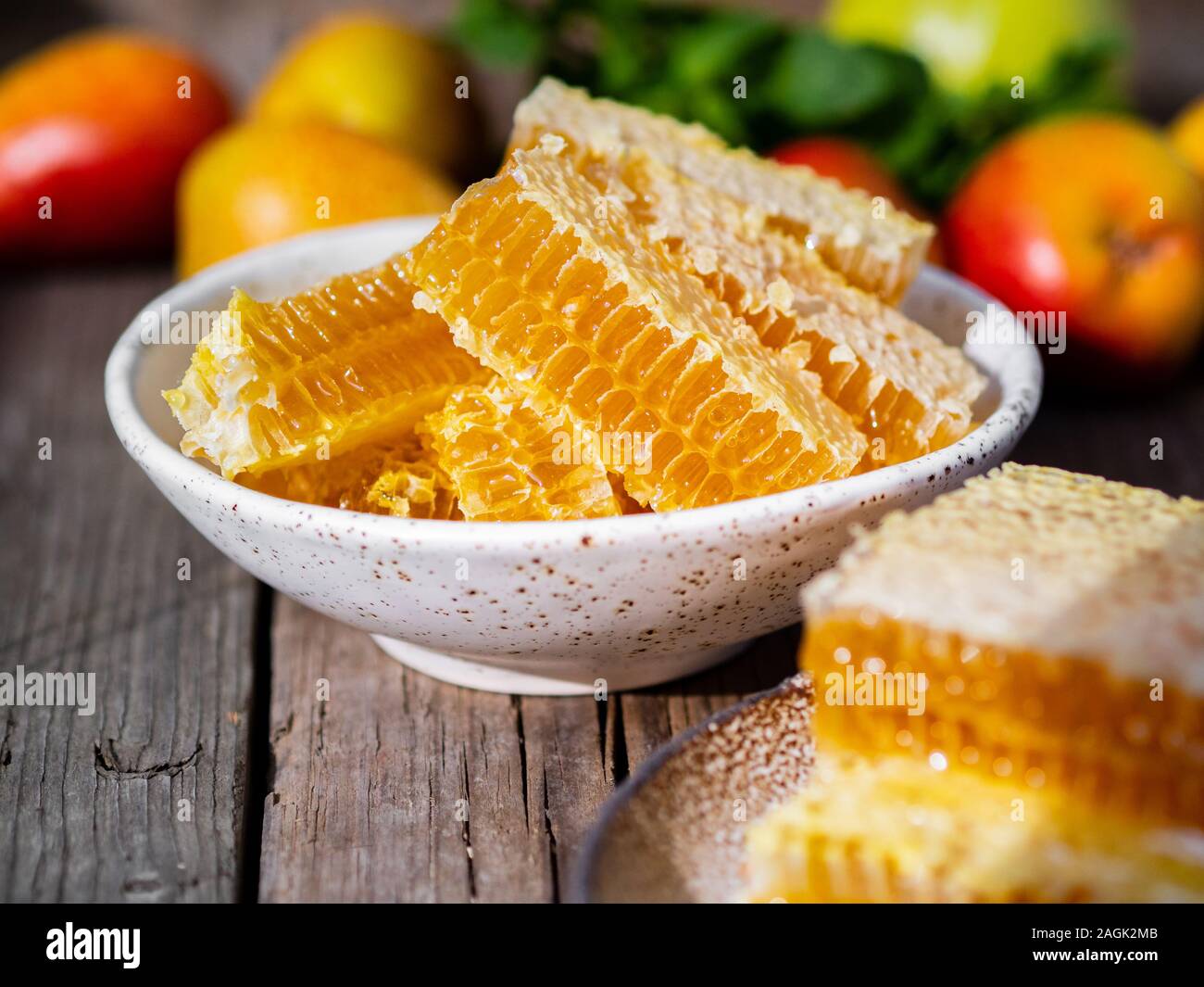 honey in honeycomb, close-up, on white ceramic plate, on wooden rustic ...