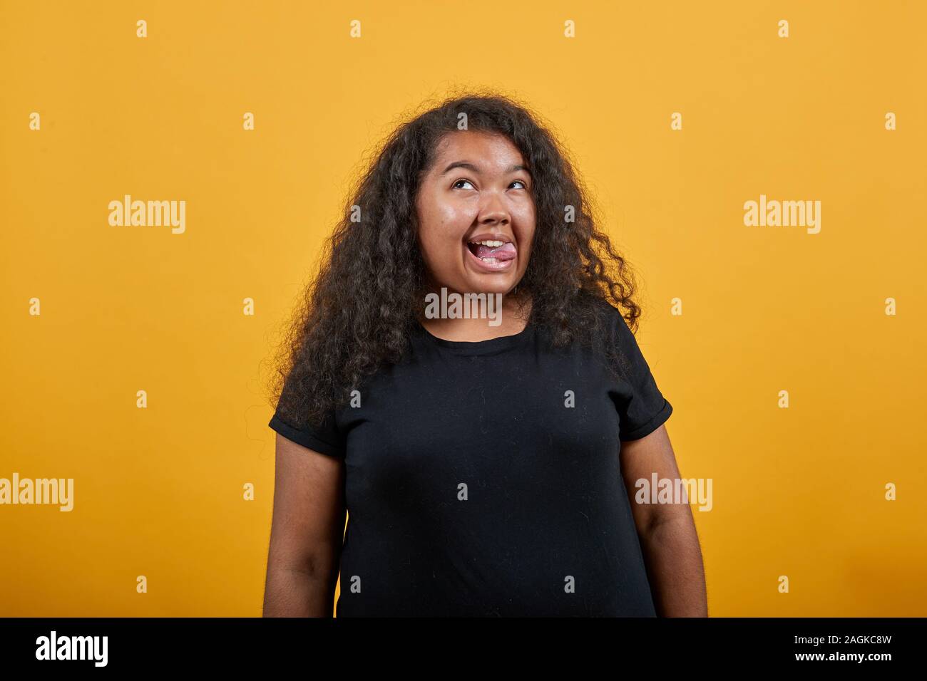 Crazy afro-american young lady showing tongue Stock Photo - Alamy